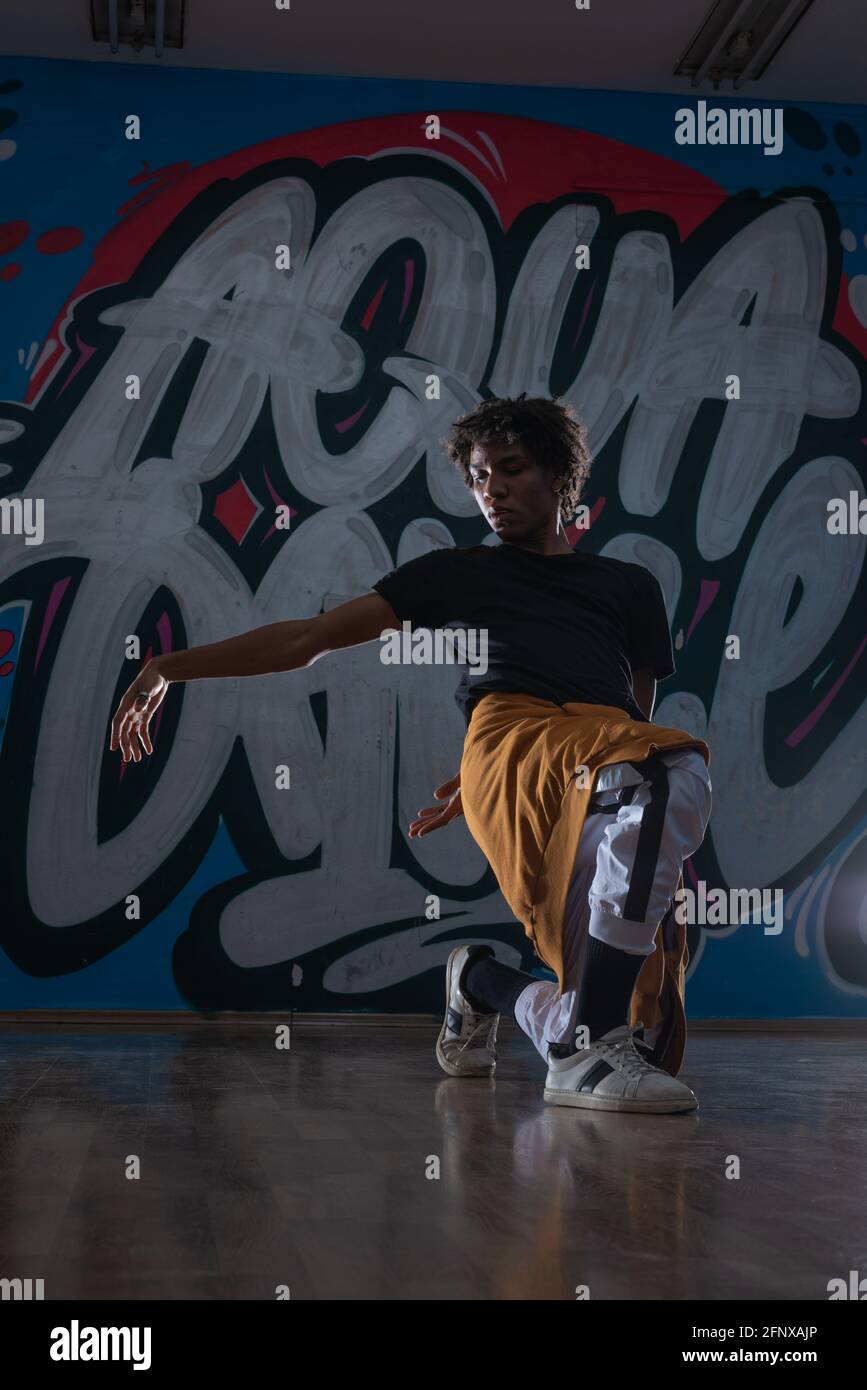 African American hip hop dancer (breakdancer) performing over graffiti ...