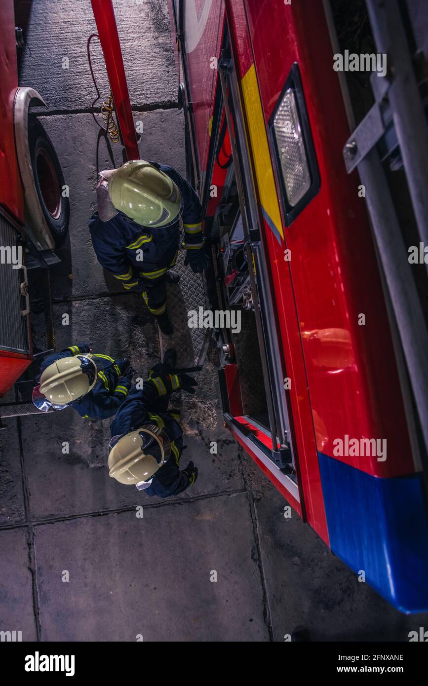 Firemen checking the fire engine inside the fire department from a bird ...