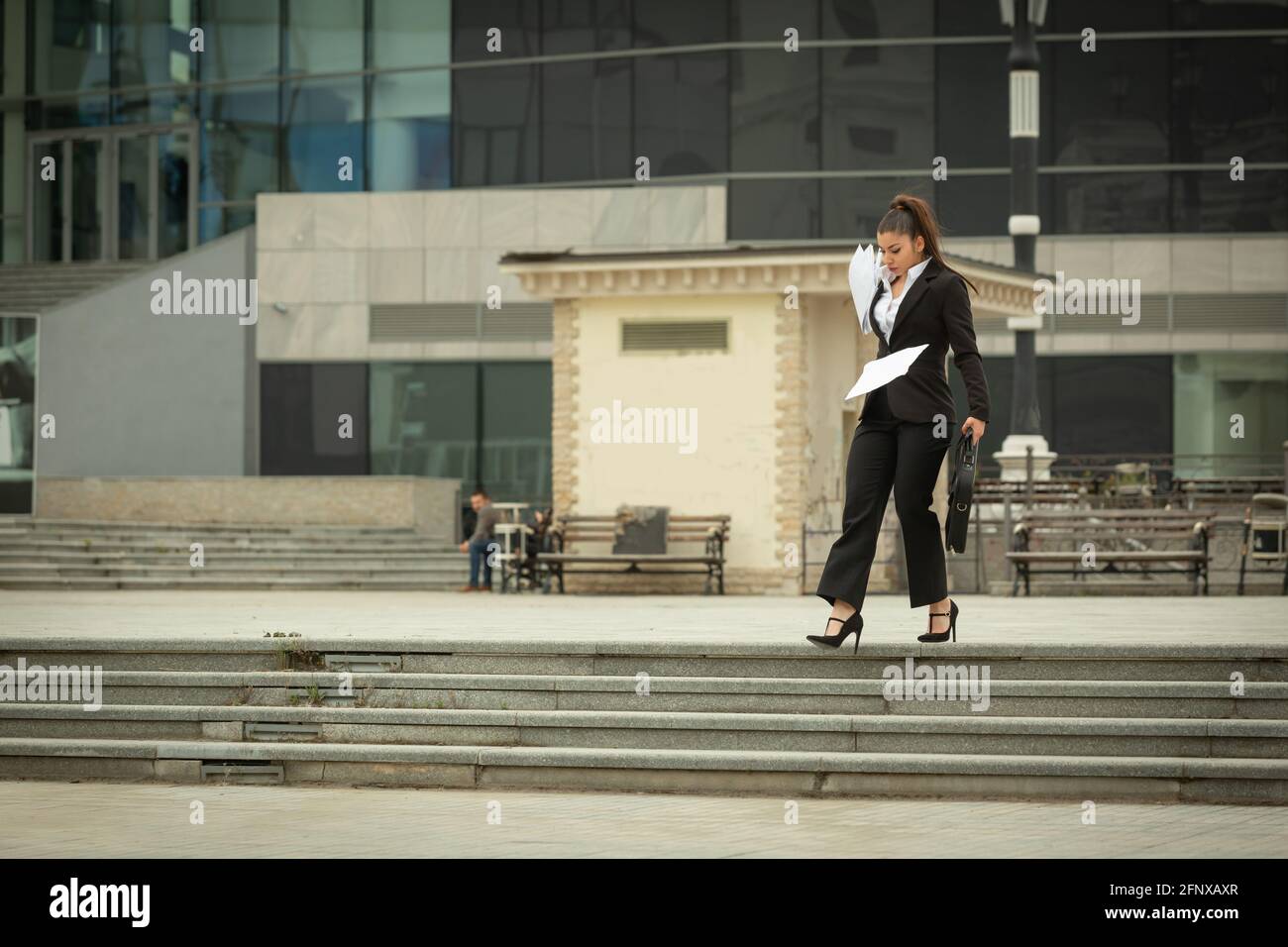 Attractive italian businesswoman is walking while throwing the papers ...