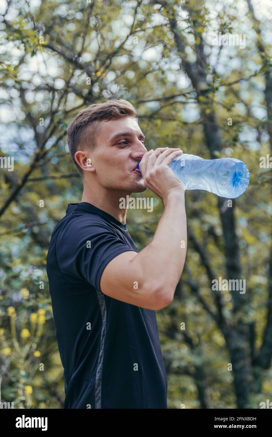 Male athlete drinking water, refreshing, hydrating after a long ...