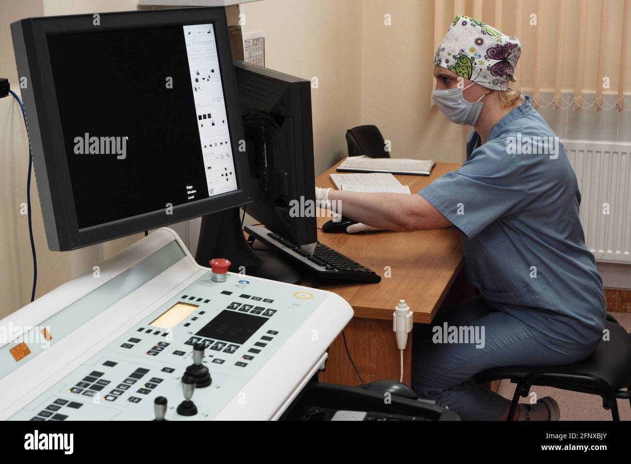 A woman radiologist behind the monitor makes an X-ray correction Stock ...