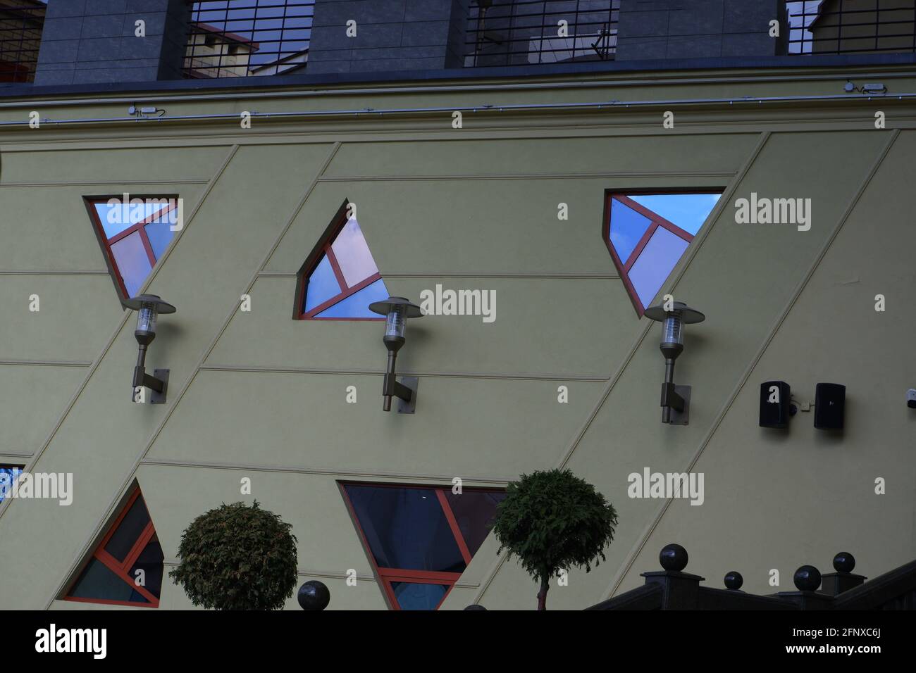 Unusual irregular geometric shapes of the windows reflect the evening ...