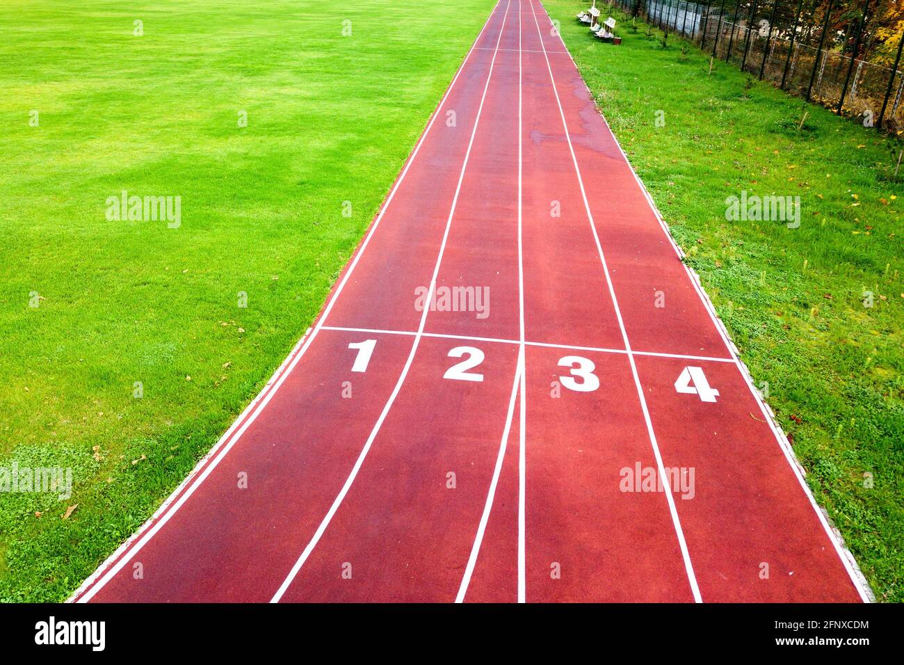 Aerial view of sports stadium with red running tracks with numbers on ...