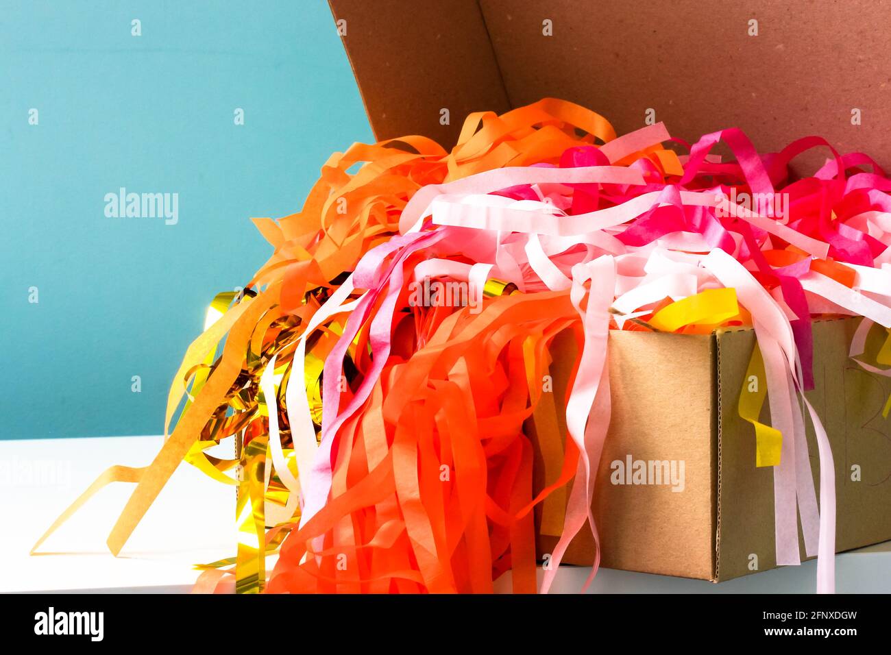 Colorful paper tassel garlands in a cardboard box on a table against ...