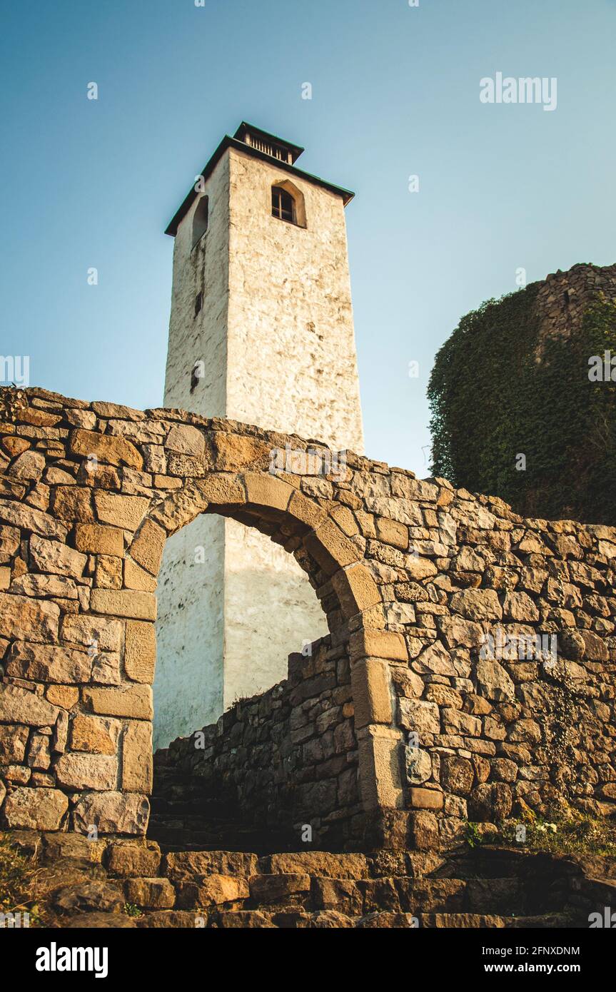 Medieval watchtower behind a brick arch wall in daylight Stock Photo ...