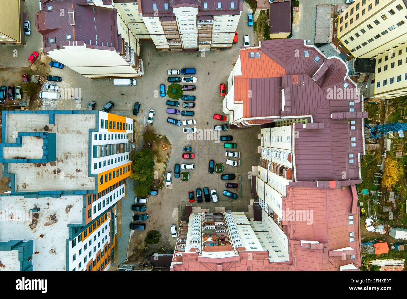 Aerial view of parked cars on parking lot between high apartment ...