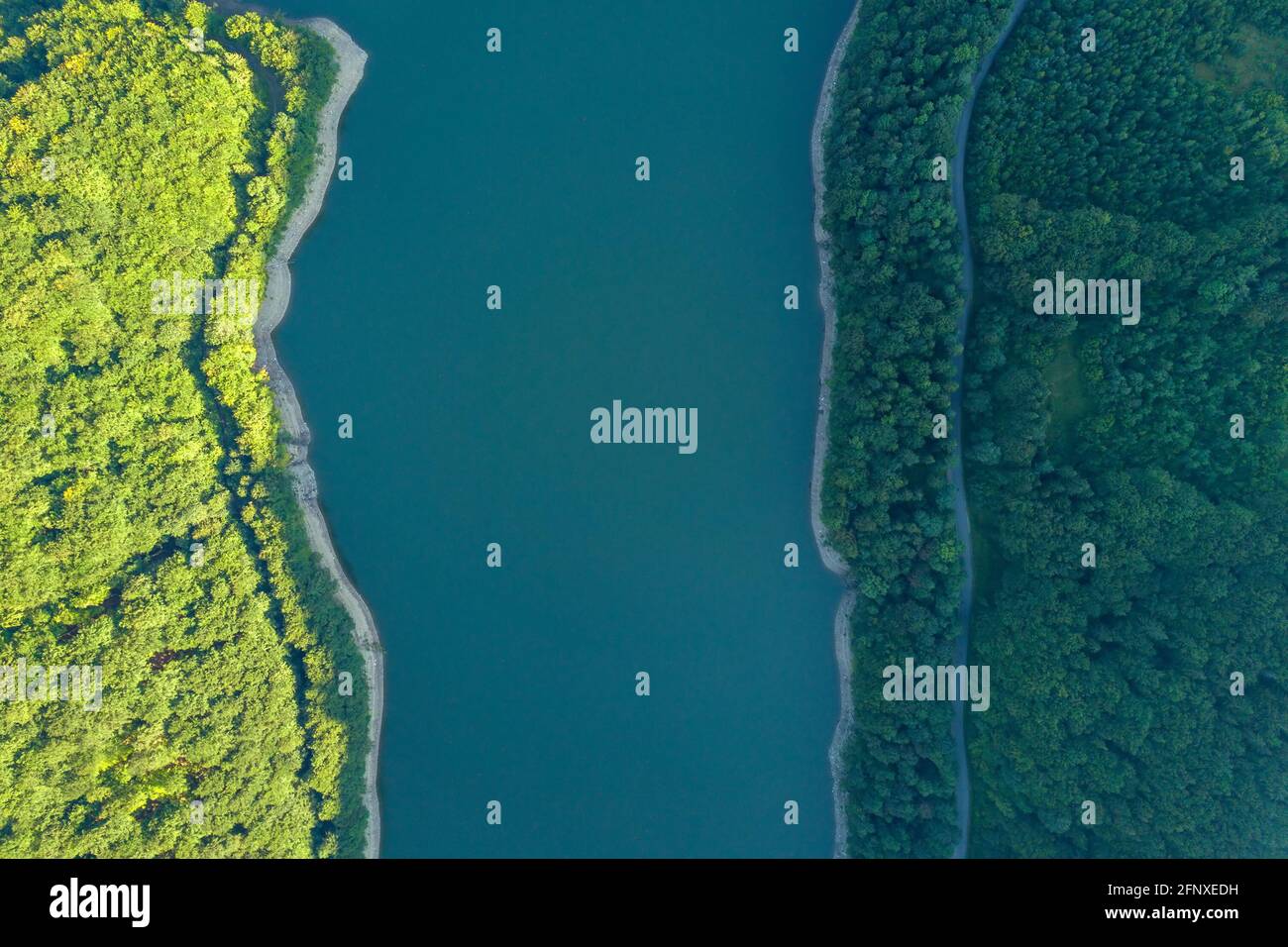 Top down aerial view of big lake with clear blue water between high ...