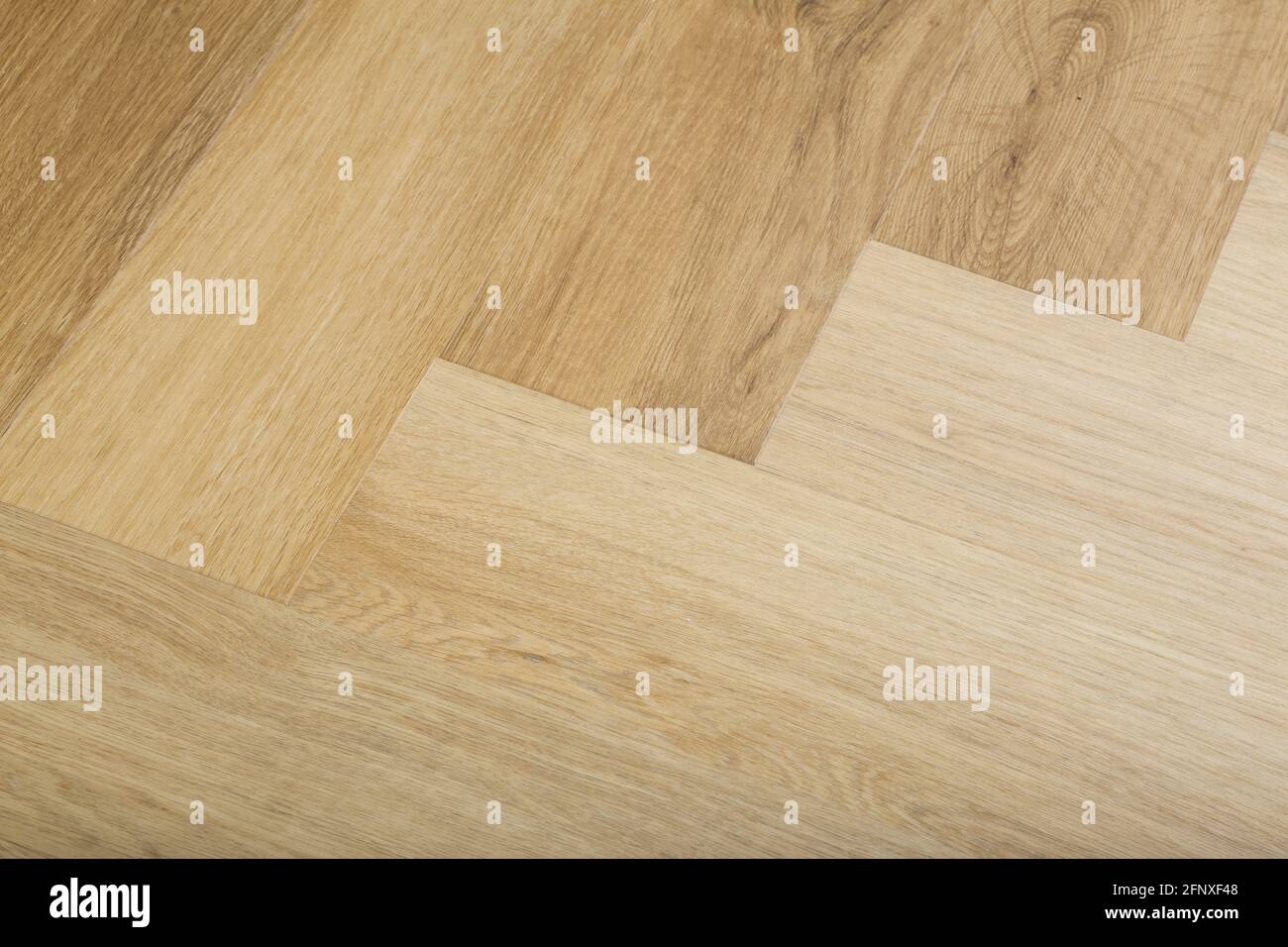 Laminate and parquet with herringbone background. Wooden floor with a ...