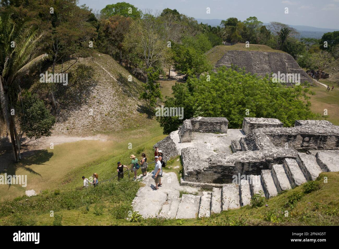 A tour group visiting the Mayan ruins of Xunantunich, The Stone Maiden ...