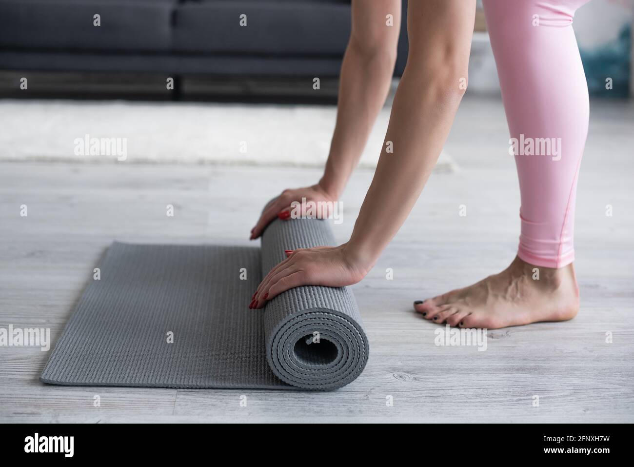 partial view of barefoot woman unrolling yoga mat on floor Stock Photo ...