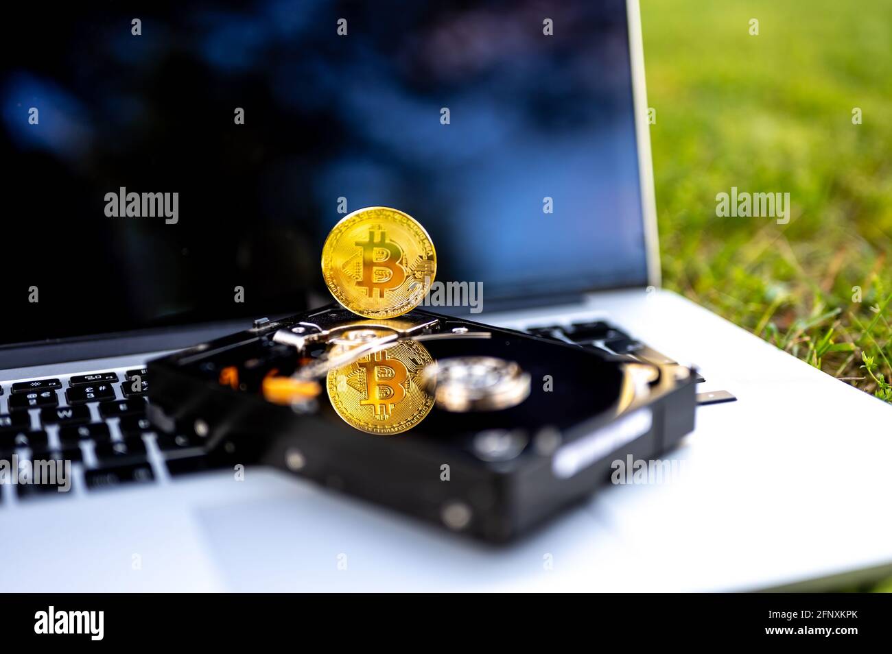 View on a laptop and a hard disk drive with a bitcoin representing ...
