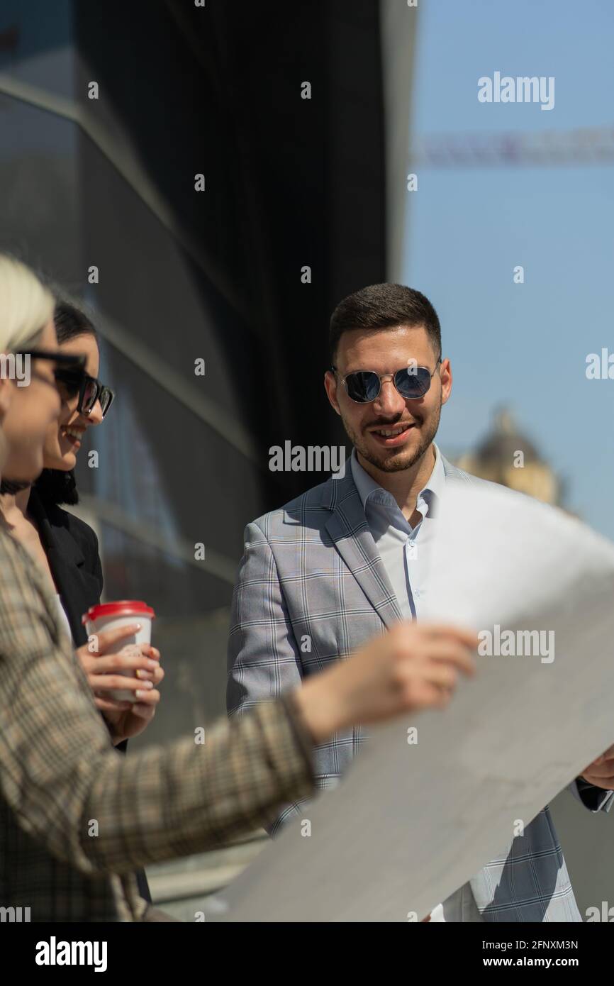 Three business people are talking and smiling about the plan for their ...