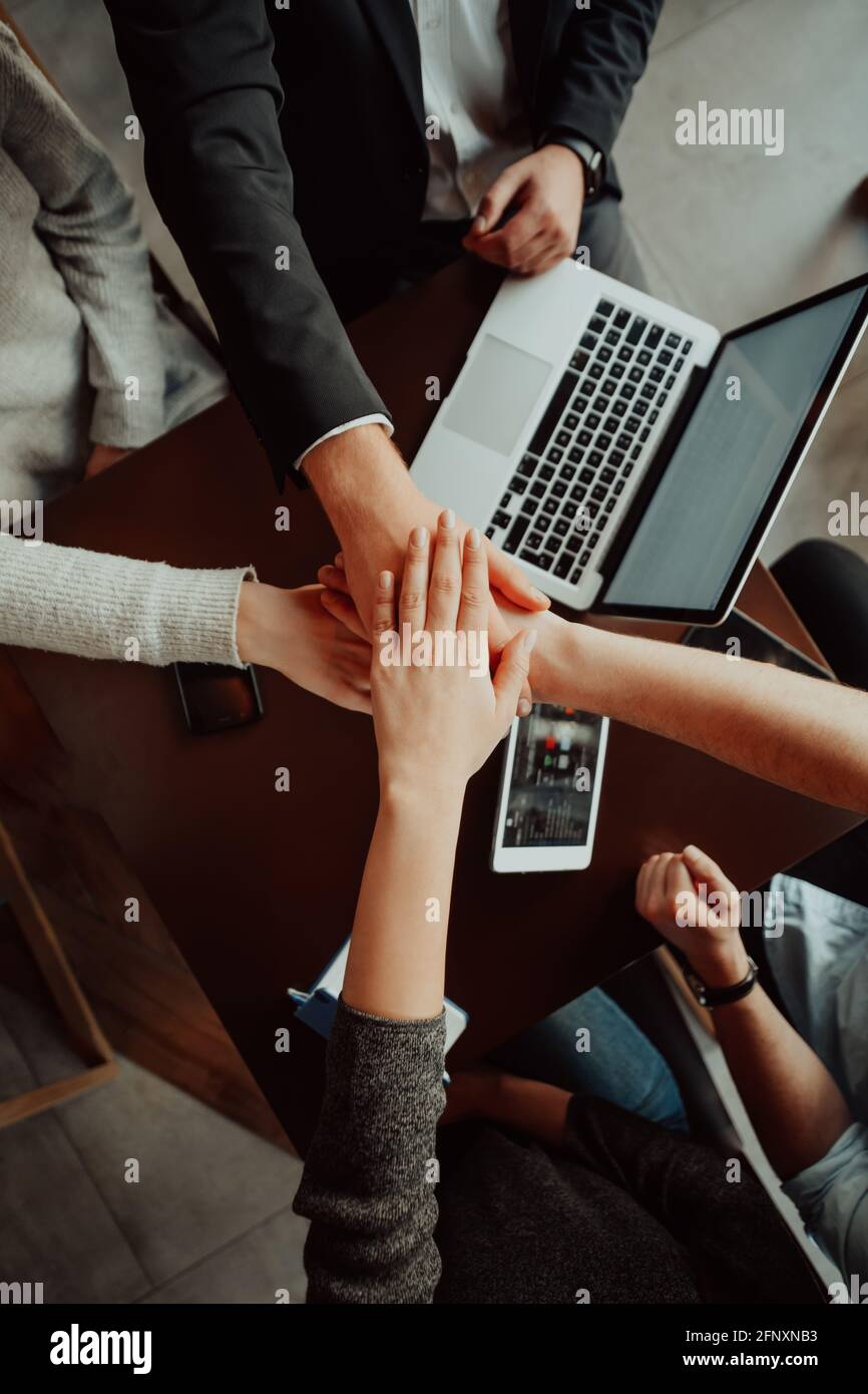 Close up of young business people putting their hands together. Stack ...