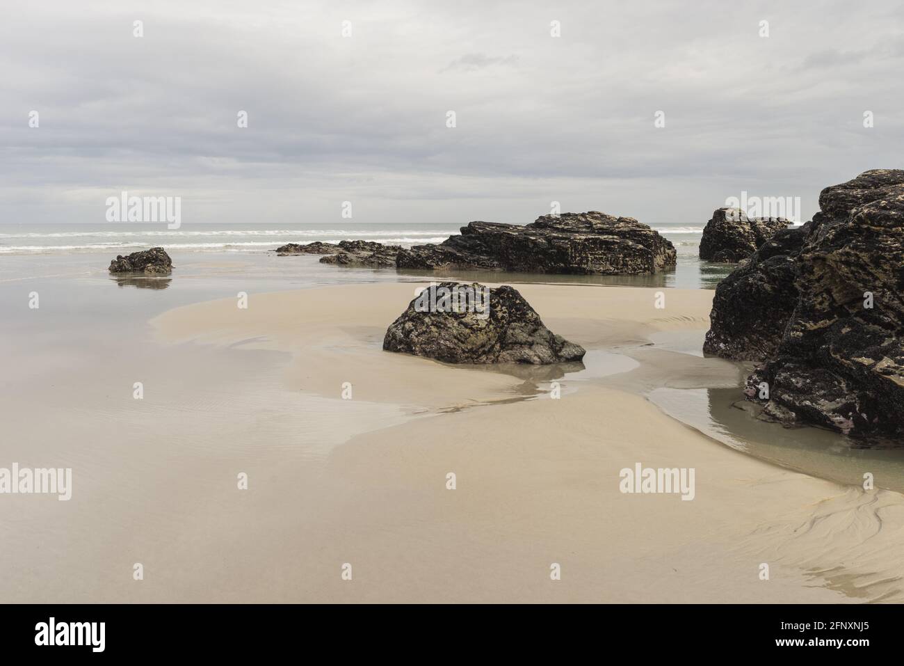 Landscape of a beach covered in rocks and sand surrounded by the sea in ...
