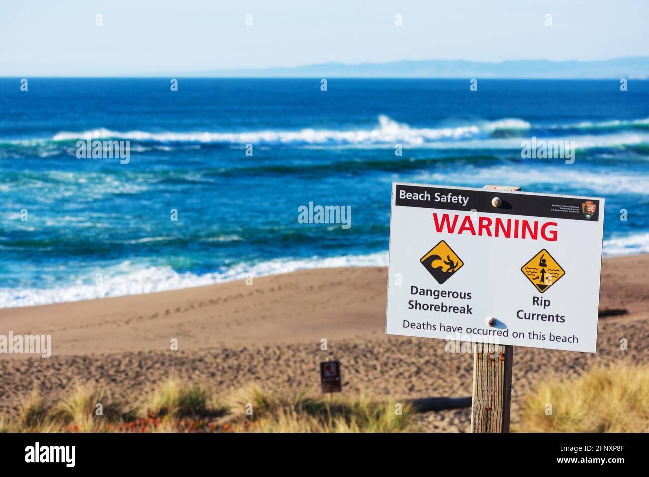 Beach safety warning sign informs visitors about dangerous shorebreak ...