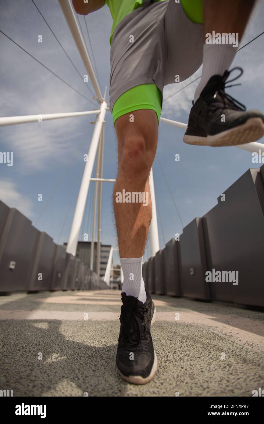 Strong a ahandsome guy is running above the camera, low angel Stock ...