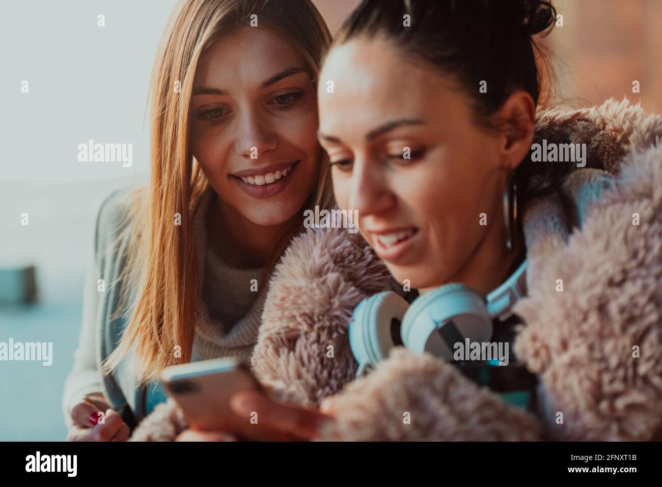 two friends stand in front of the university and use a smartphone Stock ...