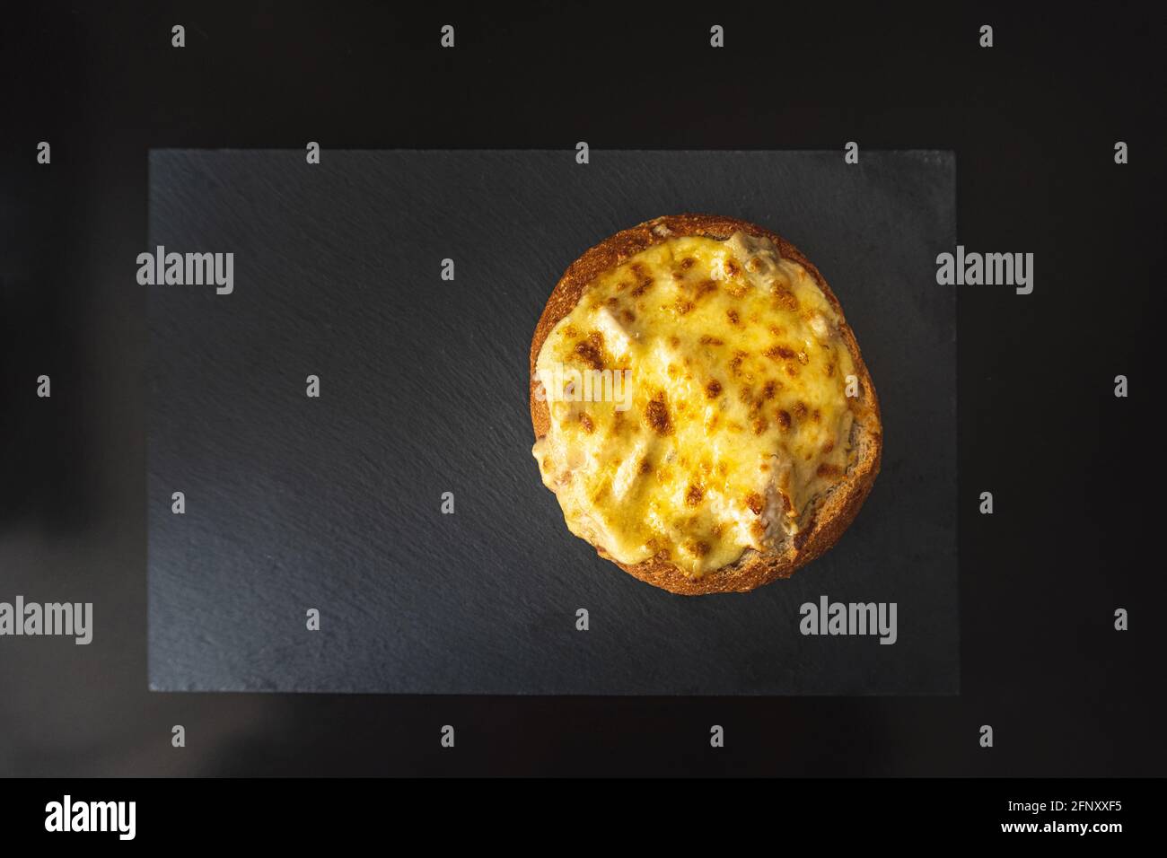 top view of crusty round baked bread stuffed with grilled cheese on a ...