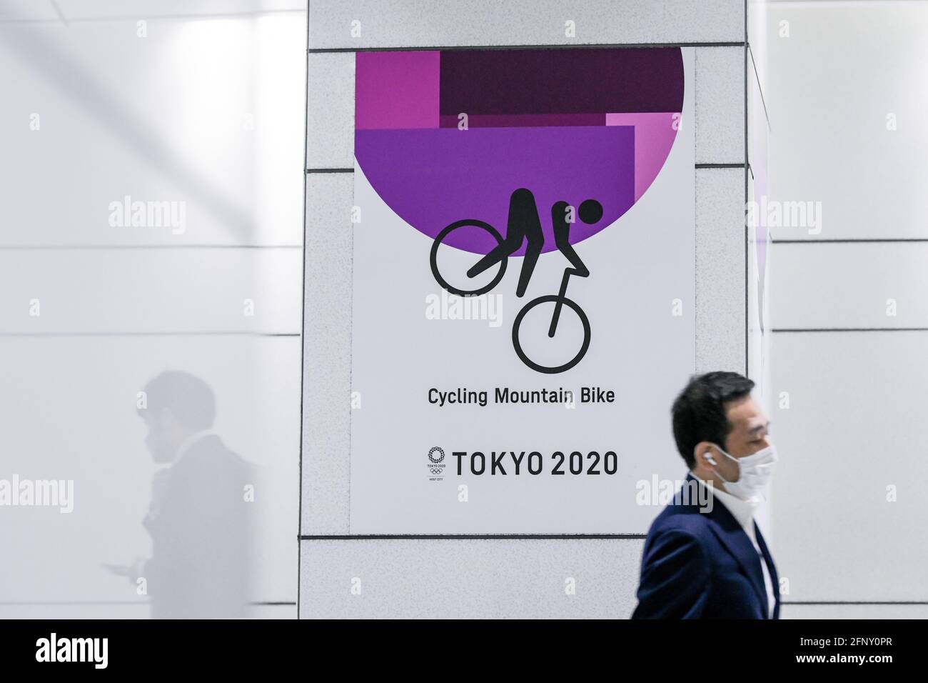 A man walks past a Tokyo 2020 advertising poster at the Shinjuku Metro ...
