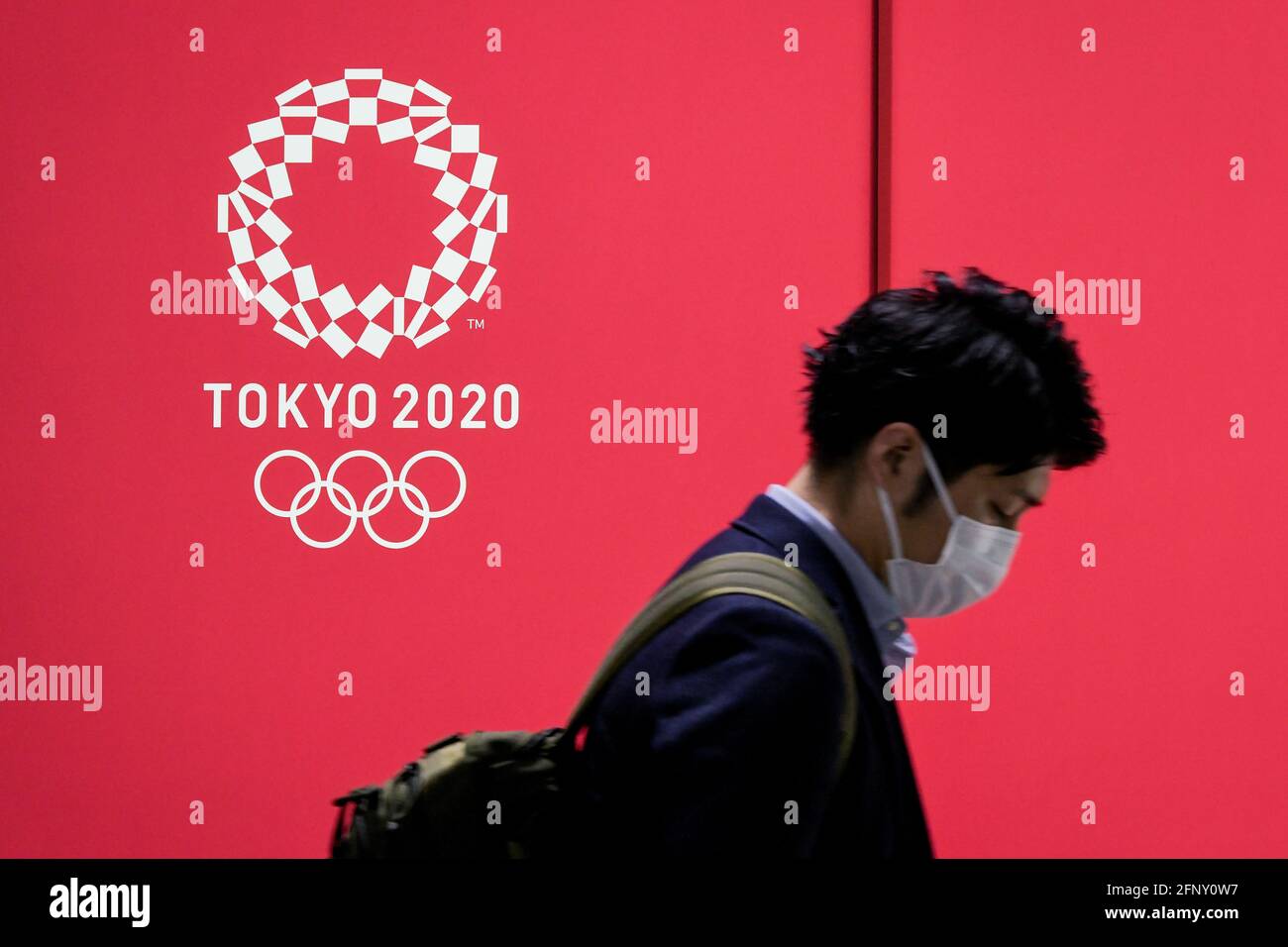 A man walks past a Tokyo 2020 advertising poster at the Shinjuku Metro ...