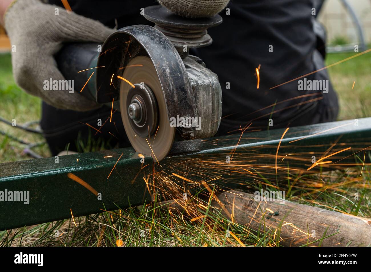Close-up on the sides fly bright sparks from the angle grinder machine ...