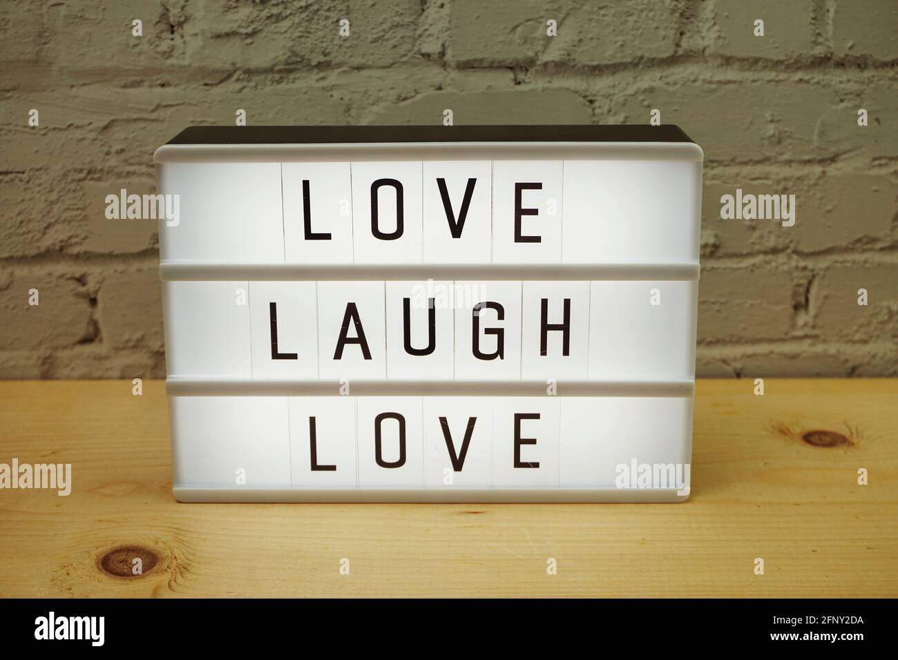 Live Laugh Love word in light box on wooden shelf and white brick wall ...