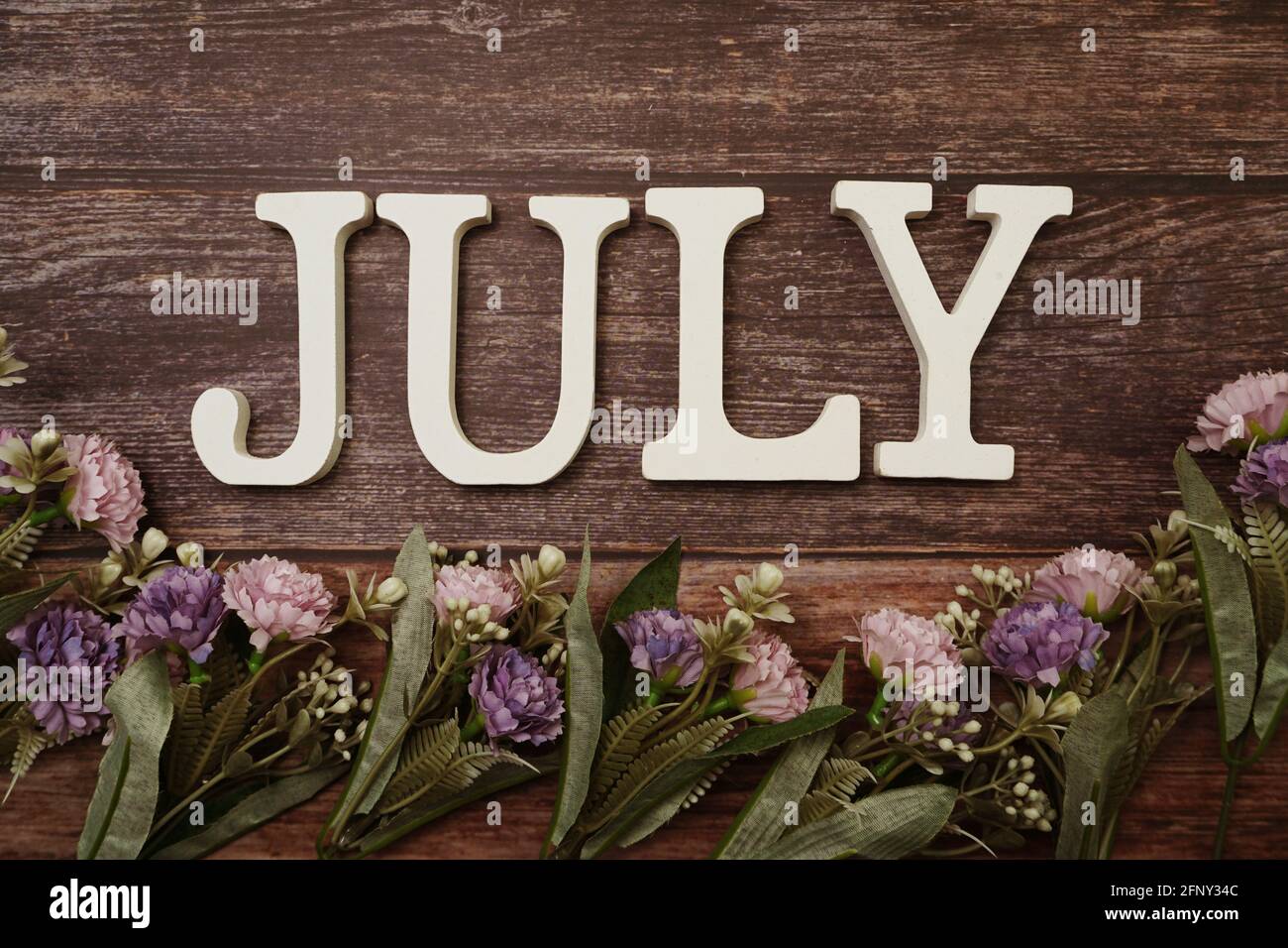 July alphabet letters with flower decoration on wooden background Stock ...