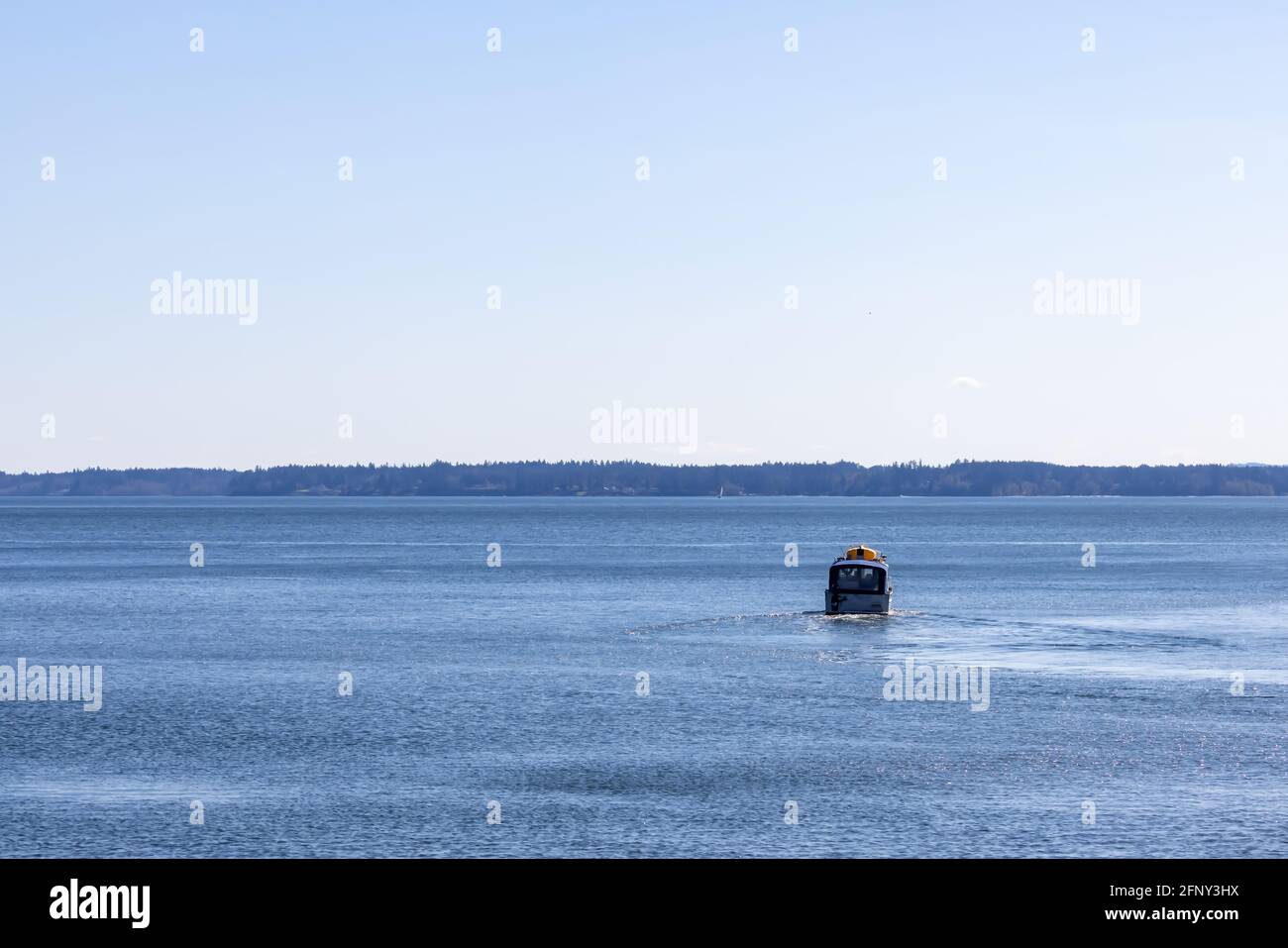 distant boat speeding off towards the horizon Stock Photo - Alamy
