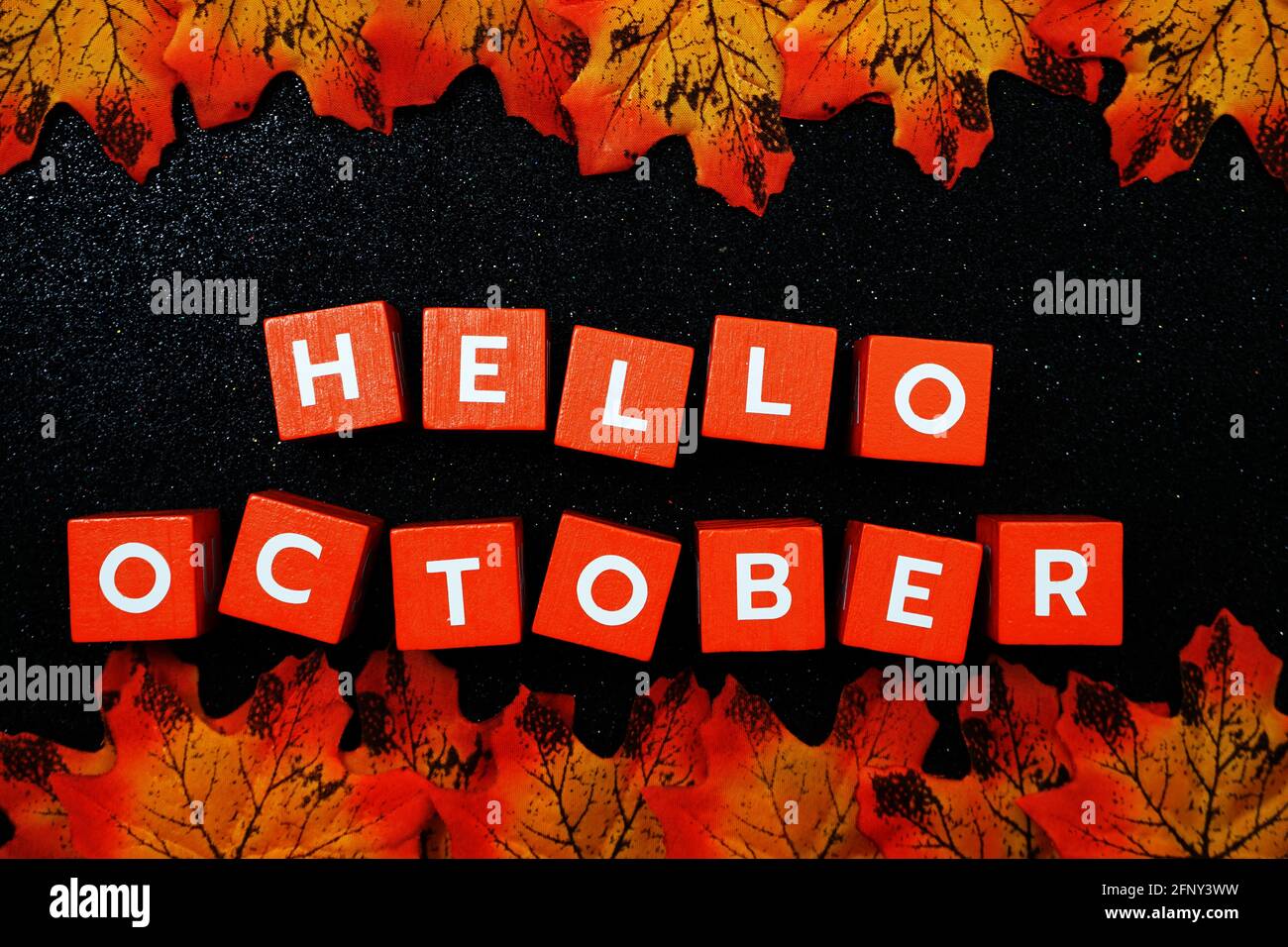 October alphabet letter with maple leave decoration on black glitter ...