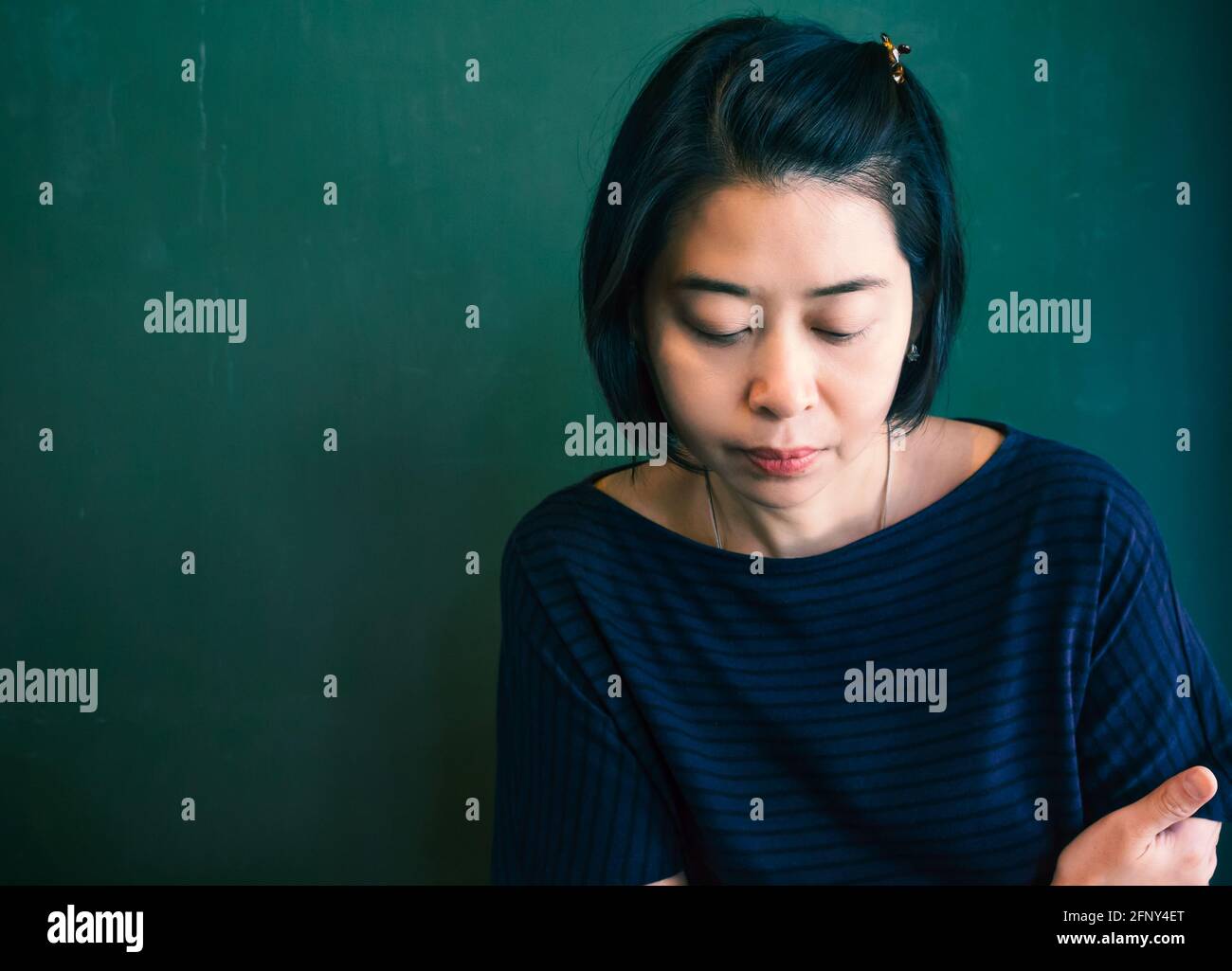 Lonely Asian woman upset. Portrait of unhappy Asian woman. Gree wall ...
