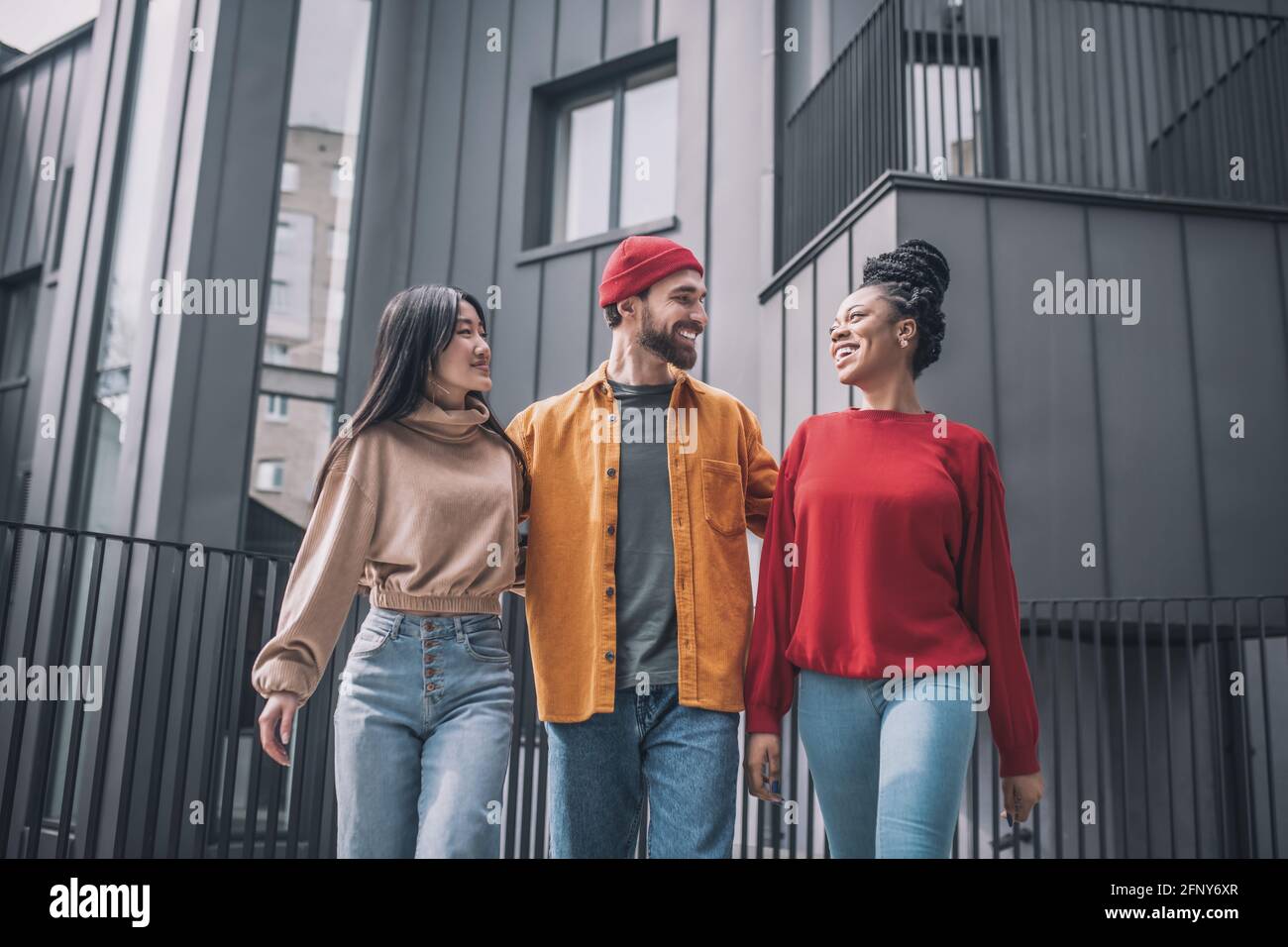 Three friends walking together and feeling good Stock Photo - Alamy