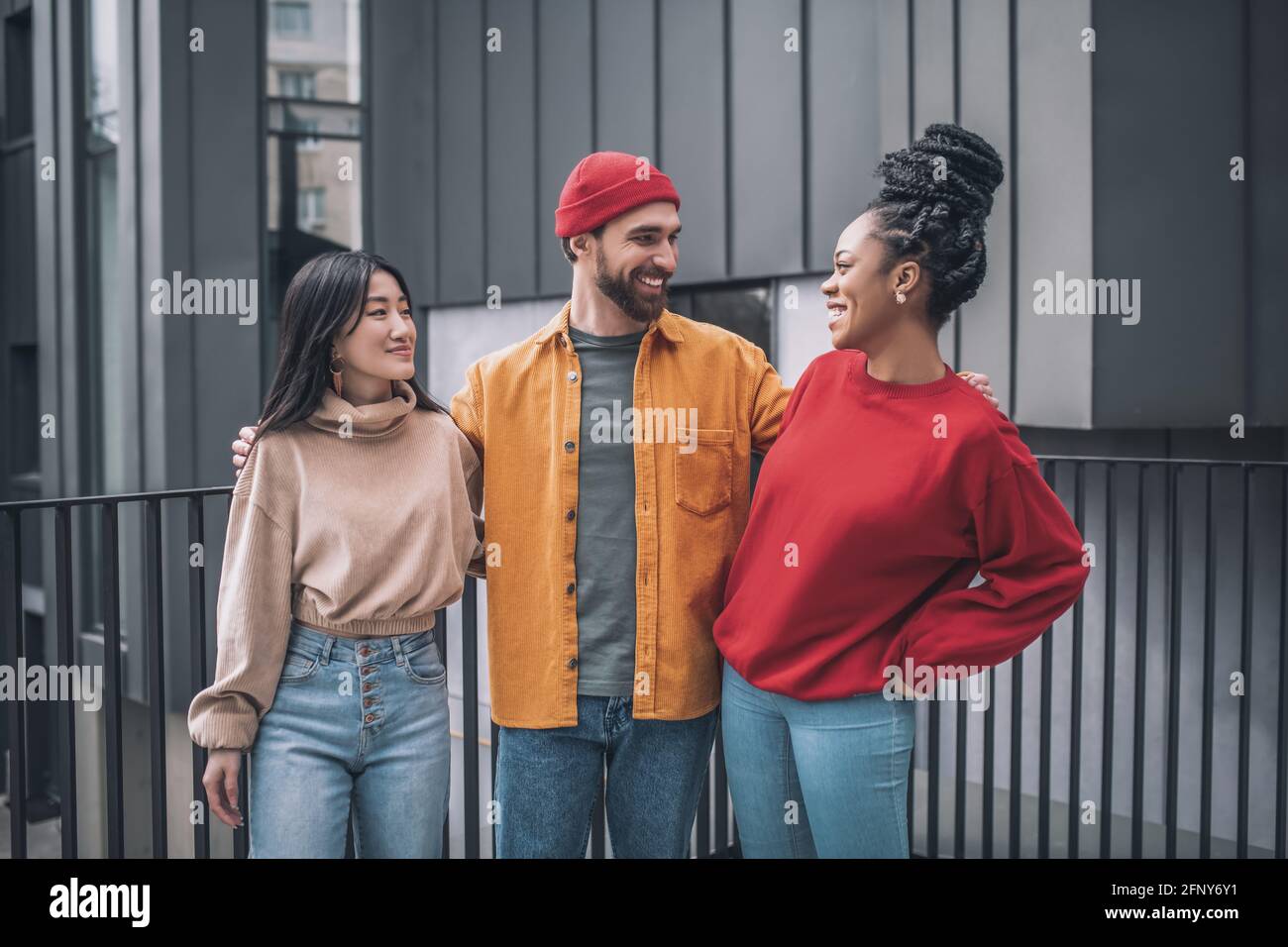 Three friends walking together and feeling good Stock Photo - Alamy