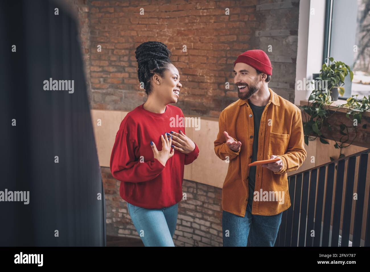 Young man and a woman talking and looking interested Stock Photo - Alamy