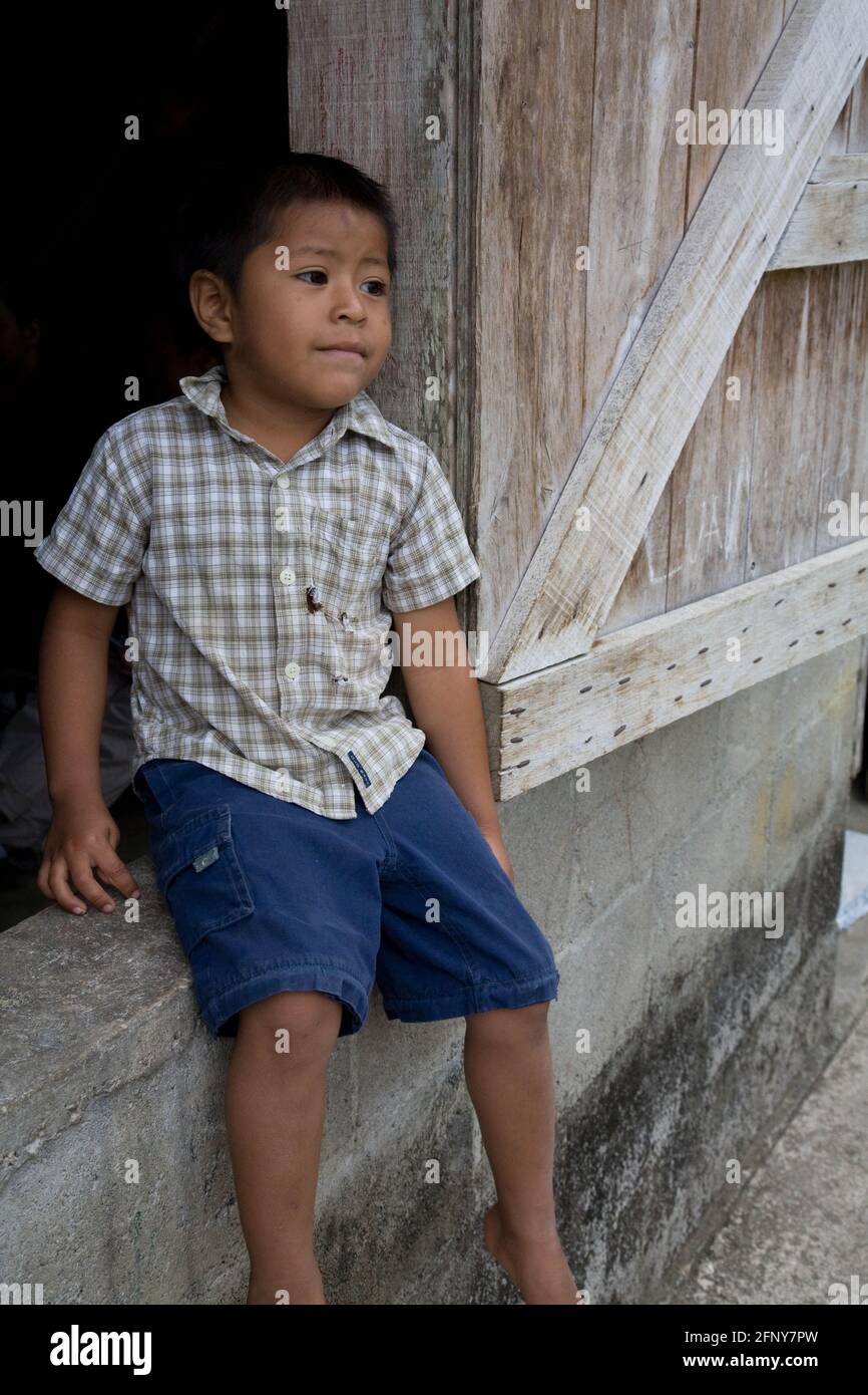 A Mayan boy sits in the window of his house in the Mayan community of ...