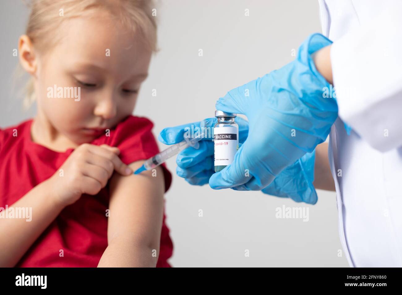 The doctor gives the child an injection of covid-19 vaccine Stock Photo ...