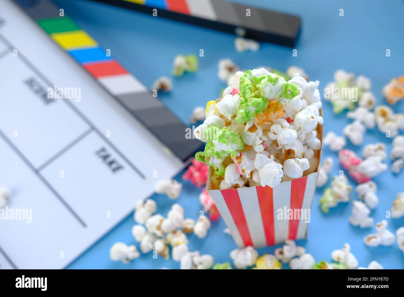 Movie clapper board and popcorn on blue background Stock Photo - Alamy