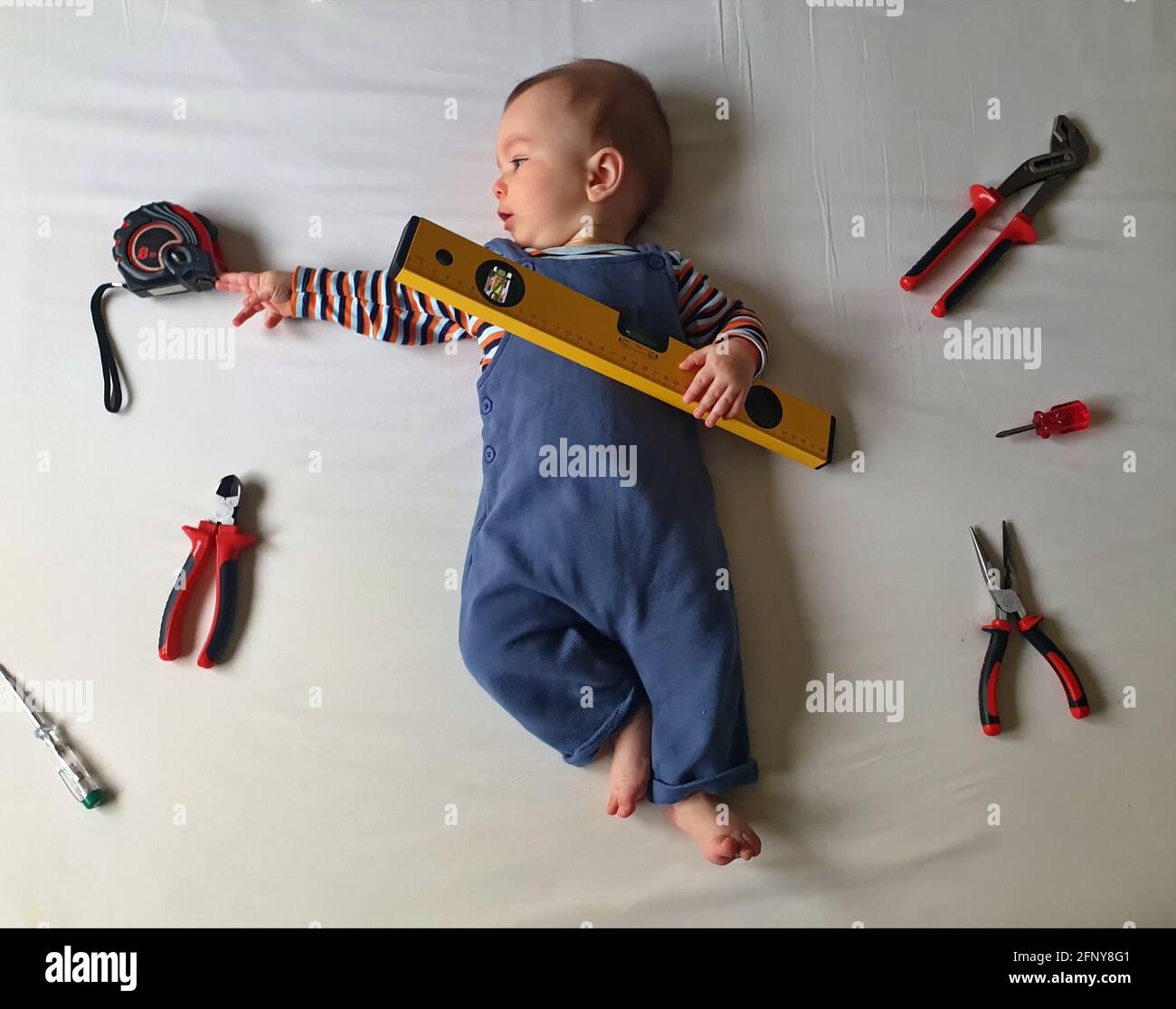 Flat lay of cute baby with mechanic tools Stock Photo - Alamy