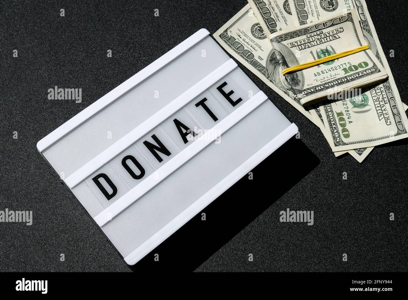 Lightbox board with word DONATE in black letters around US dollar ...