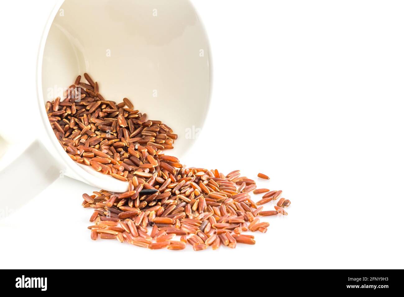brown rice close-up and cup on white background Stock Photo - Alamy