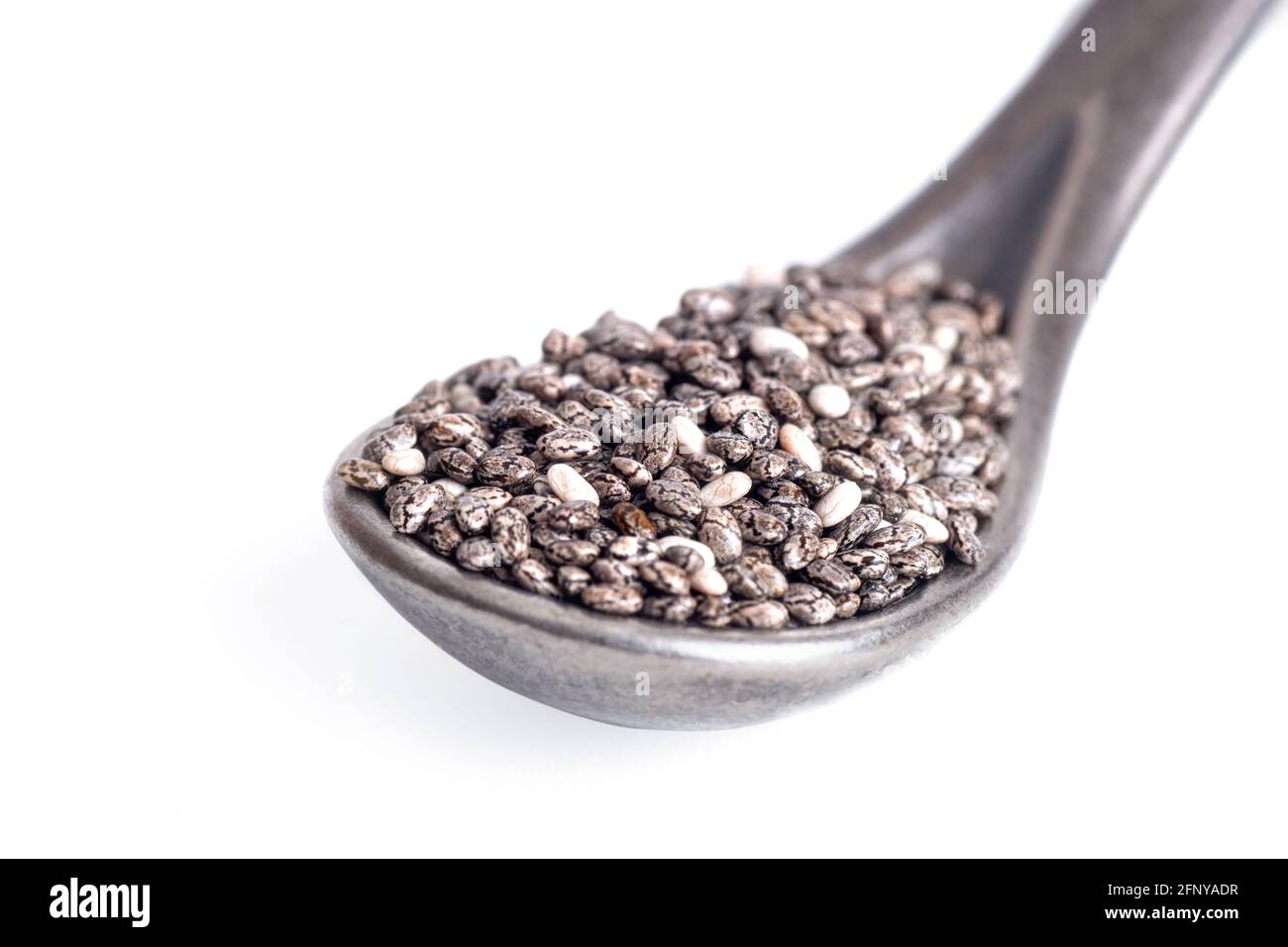 Close-up of a heaping spoon of chia seeds isolated on white background ...