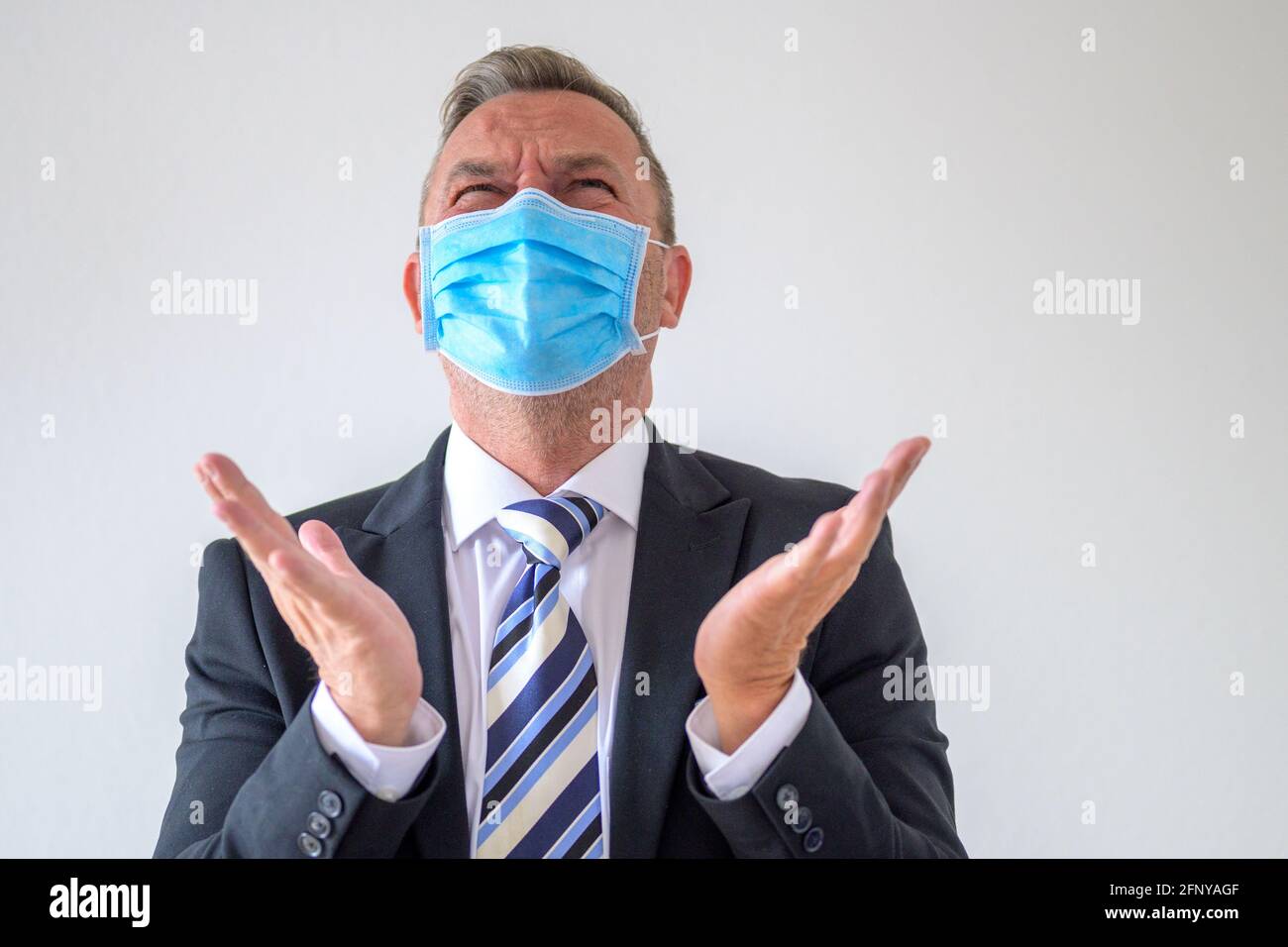 Anguished businessman wearing a face mask during the Covid-19 pandemic ...