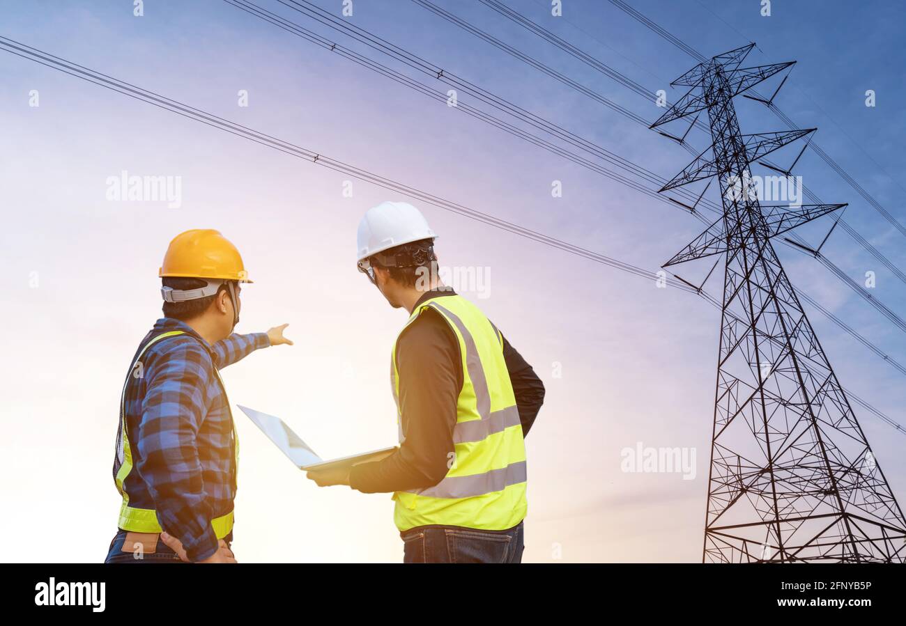 Two electrical engineer standing and watching at the electric power ...