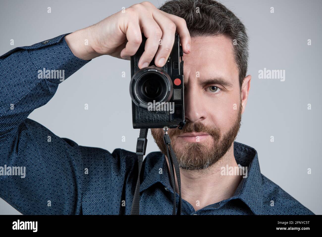 Middle-aged photographer take photograph looking in eye of handheld ...