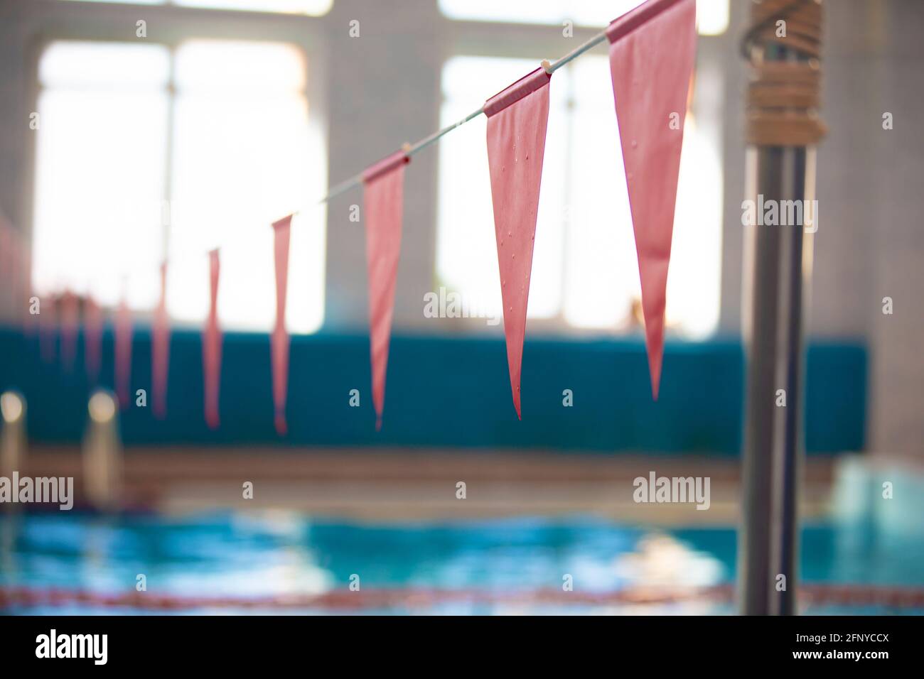 Red triangular flags against the blue water of the swimming pool Stock ...
