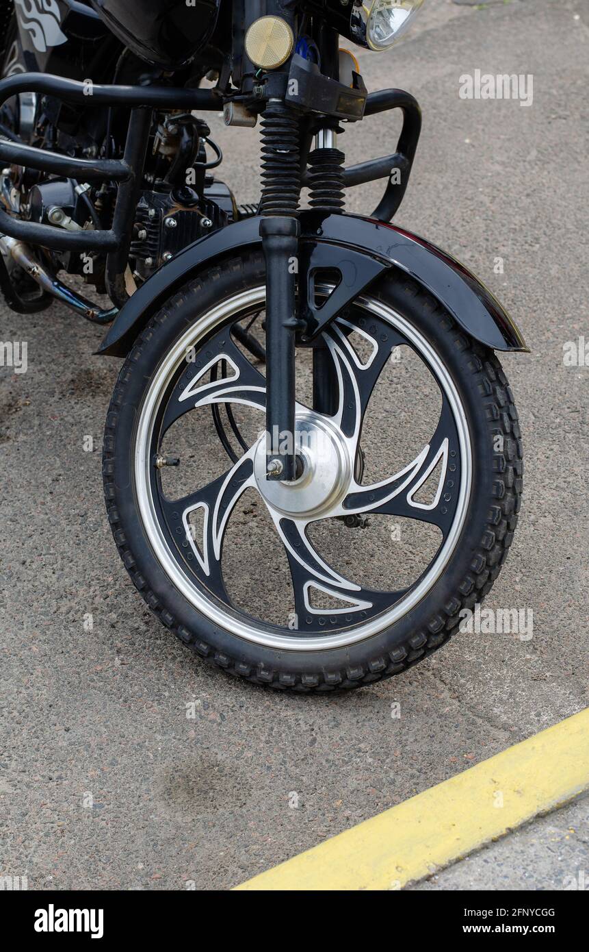 Black Motobike in the street parking lot at the yellow curb. Light ...