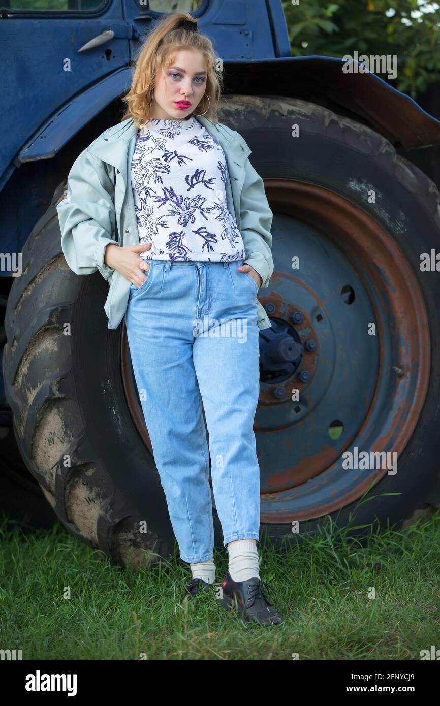 A beautiful country girl in the style of the 90s in bright clothes ...