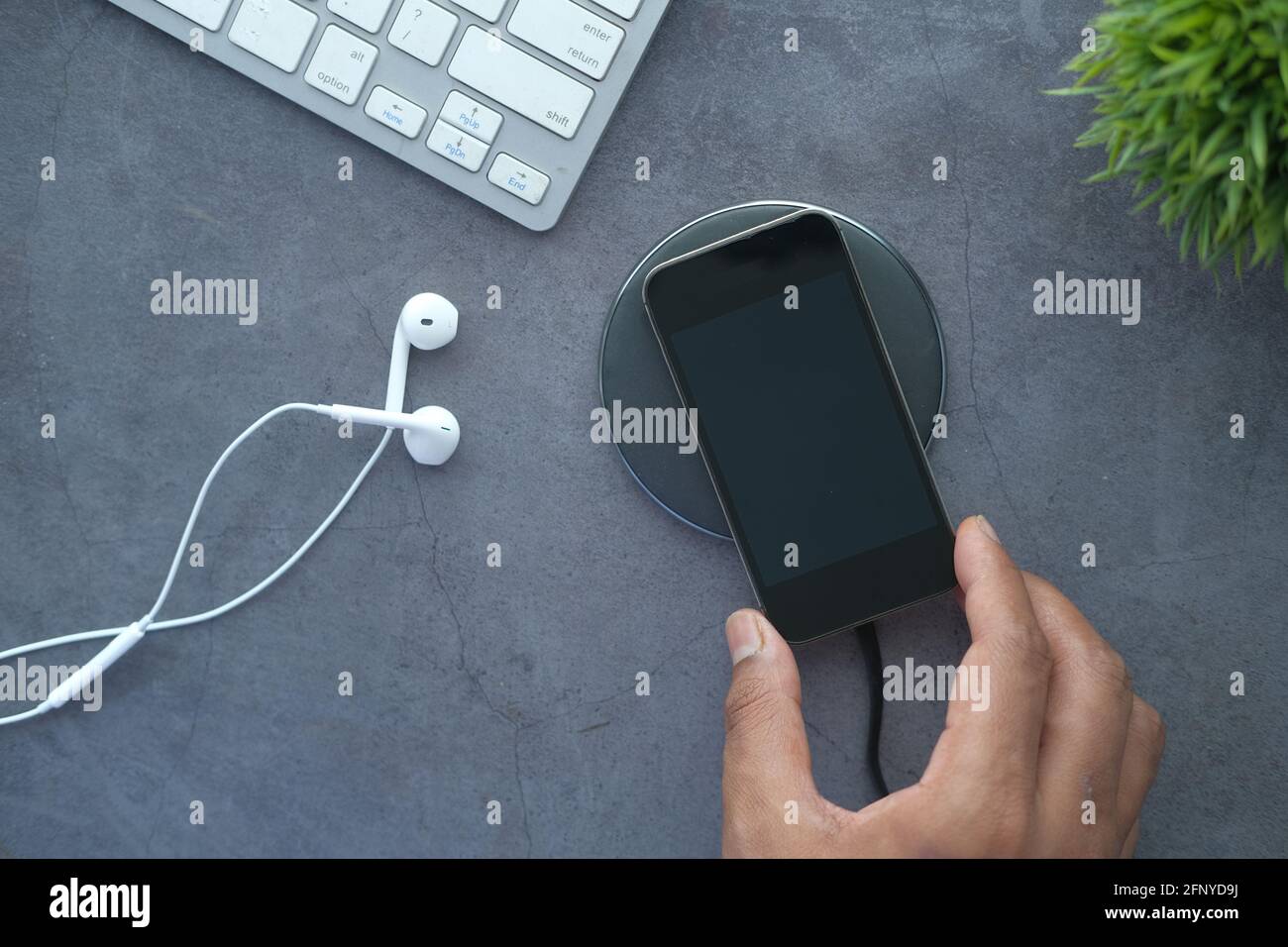 Man Hand charging Smartphone using Wireless Charging Pad, top view ...