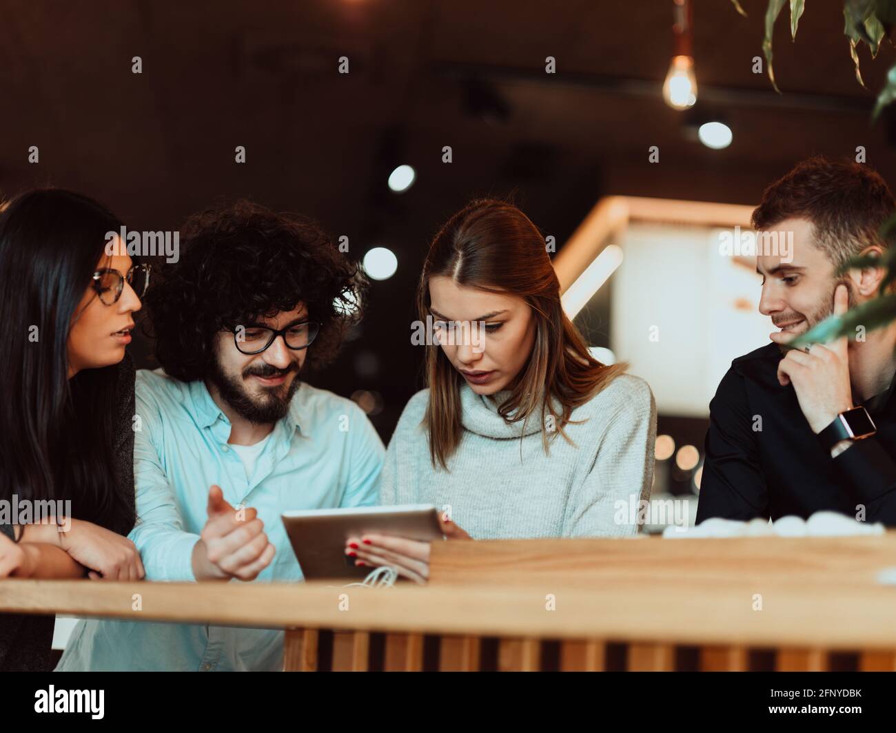 A group of friends hanging out in a cafe, and talking about business ...