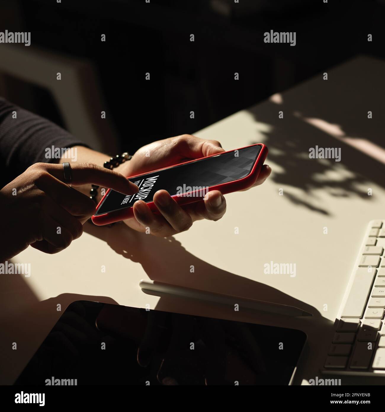 Side view of hands using smartphone while sitting at workplace, include ...