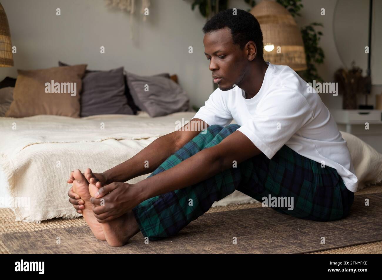 African young man sitting in paschimottanasana or Intense Dorsal ...